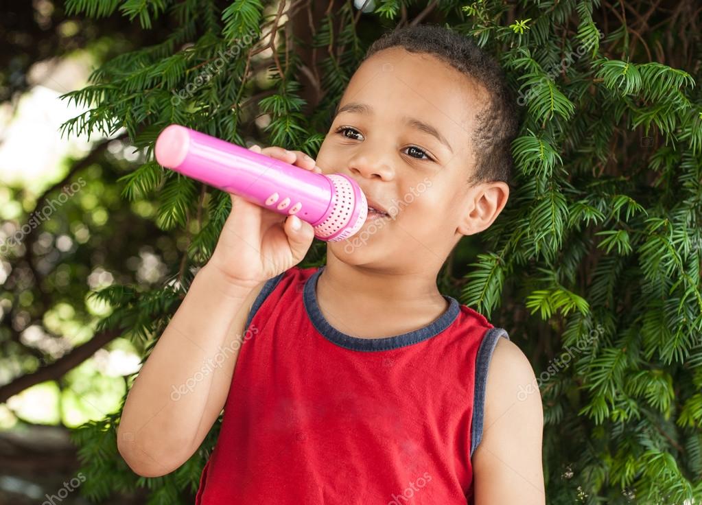 Cute little singer boy singing on the microphone in the city par Stock ...