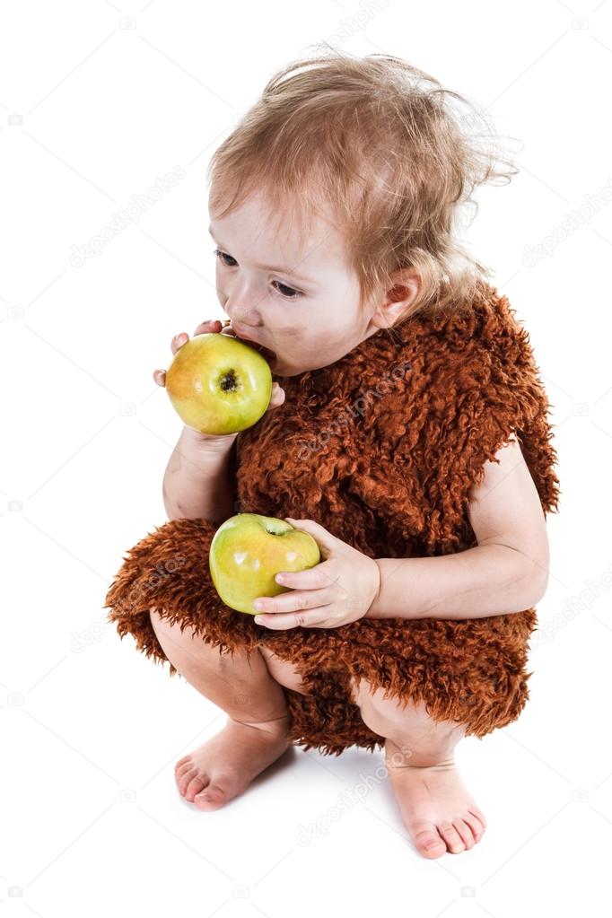 Little funny Neanderthal boy in a suit with dirty face eating an apple ...