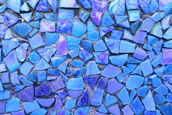 Blue mosaic tiles of irregular sizes arranged in a background motif ...