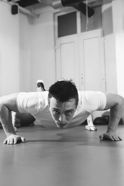 Portrait of a fitness man doing push ups in gym - Stock Image - Everypixel