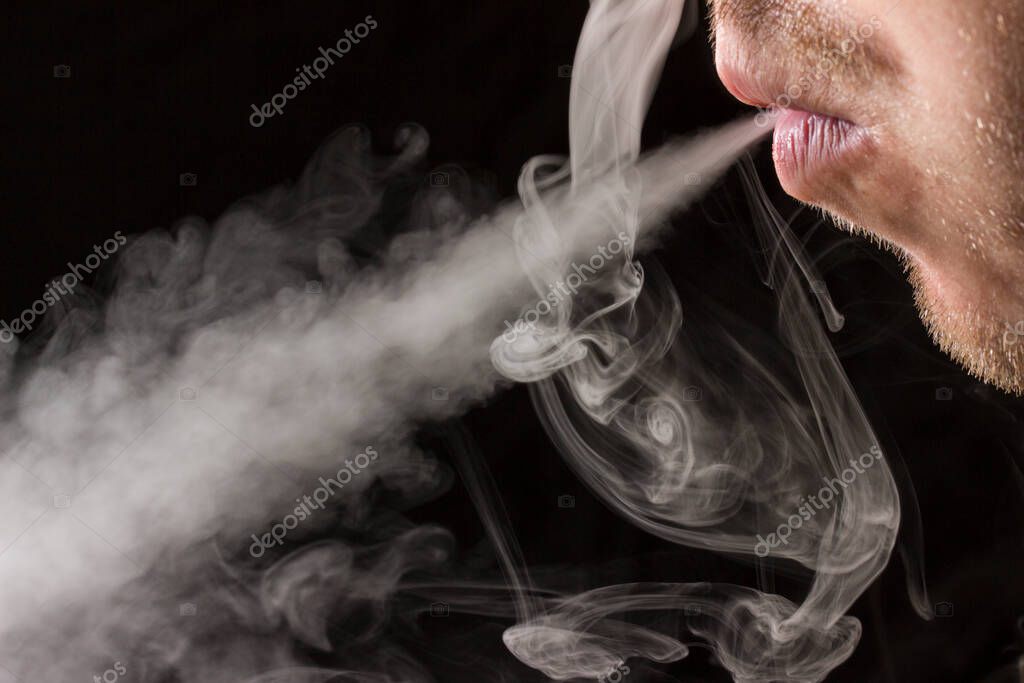 boca del hombre exhala una corriente de humo de cigarrillo sobre un ...