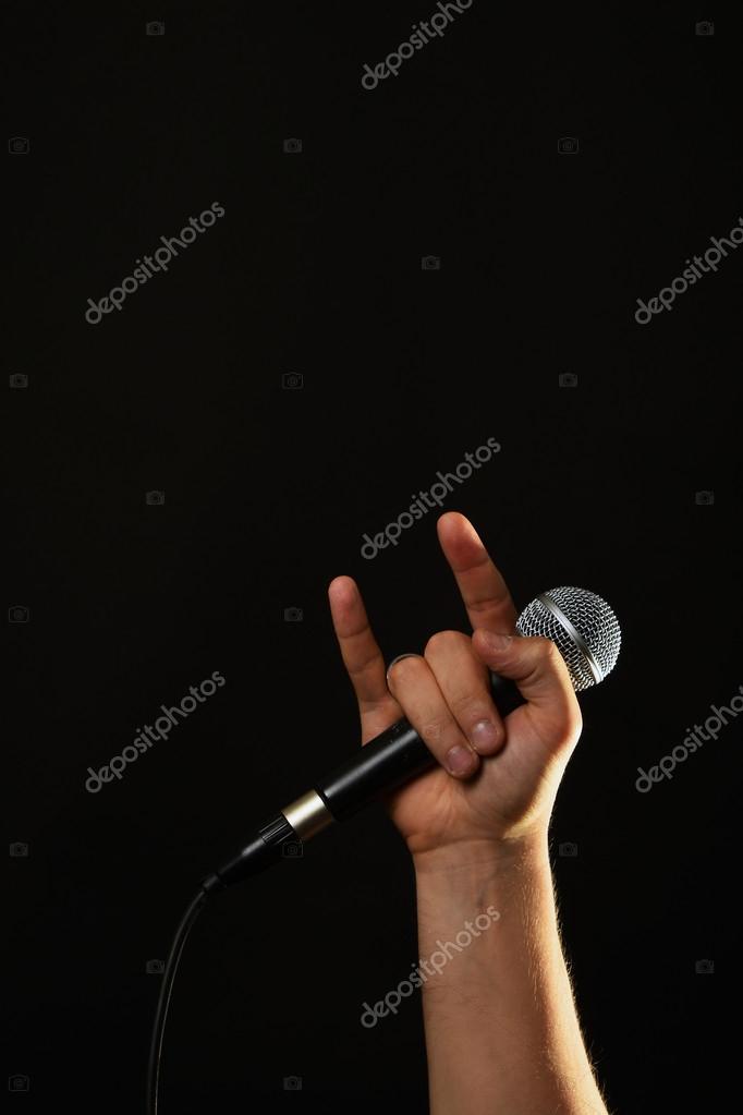 Hand with microphone and devil horns isolated on black Stock Photo by ...