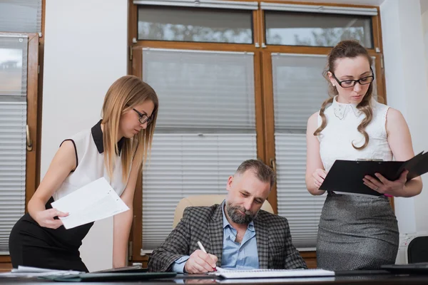 Businessman and his assistants secretaries in his office. - Stock Image ...