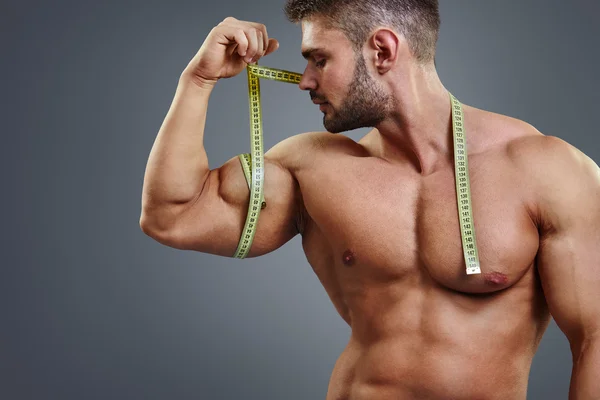 Bodybuilder measuring biceps with tape measure Stock Photo by ©kegfire ...