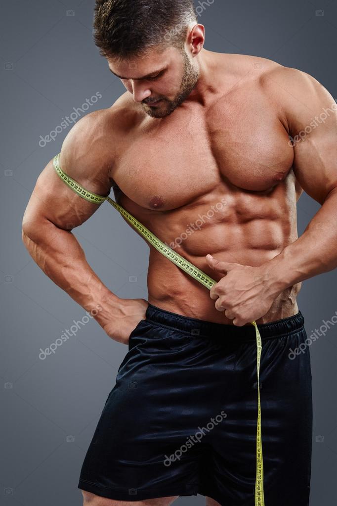 Bodybuilder measuring biceps with tape measure — Stock Photo © kegfire ...