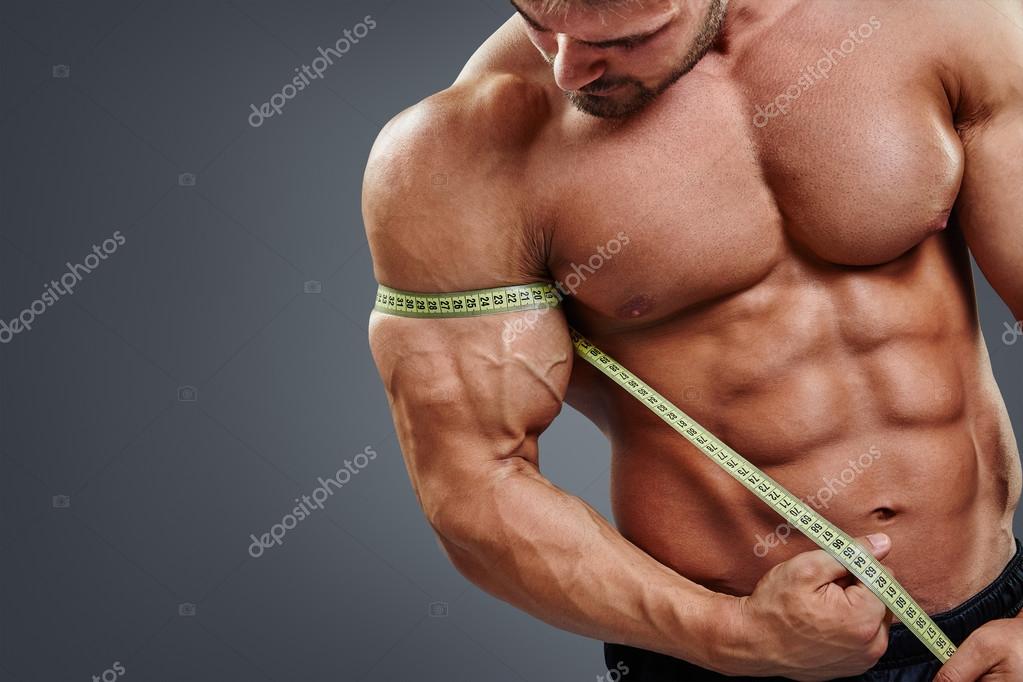 Bodybuilder measuring biceps with tape measure — Stock Photo © kegfire ...