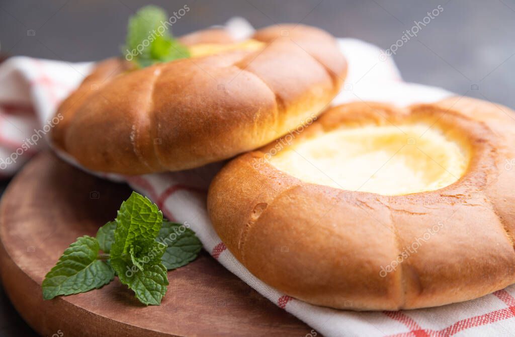 Bollo crema agria con taza de café sobre un fondo de hormigón negro y ...