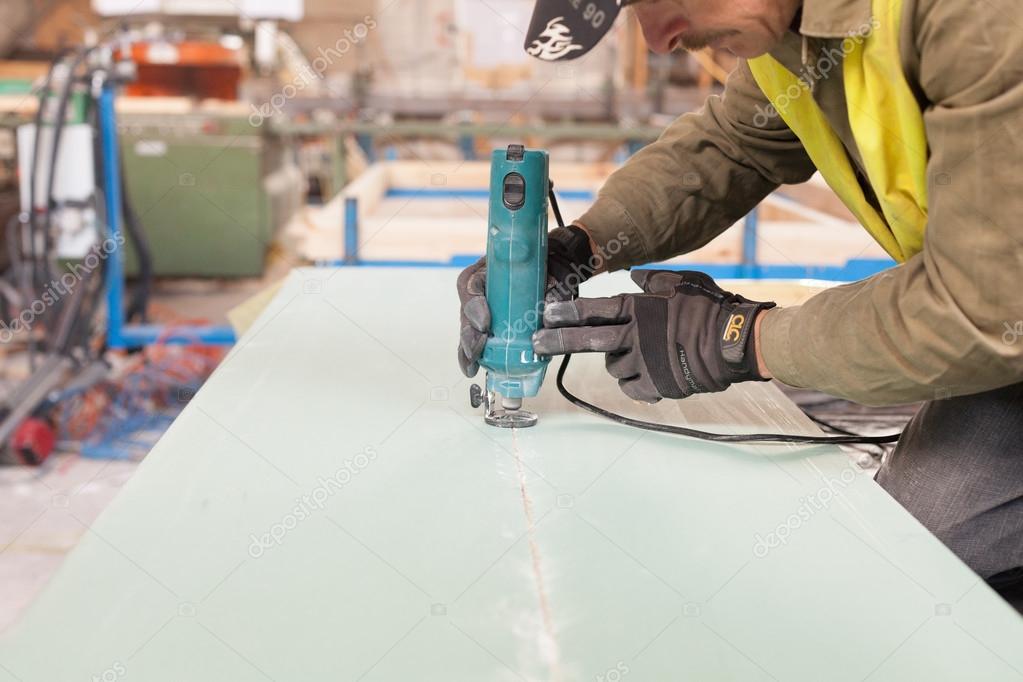 Building a wall for frame house. Worker use Laminate Trimmer for ...