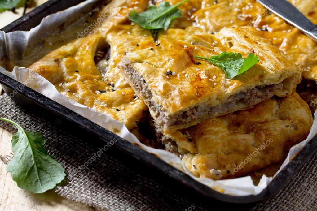 Pie with meat (minced meat and puff pastry) on vintage wooden ba Stock ...