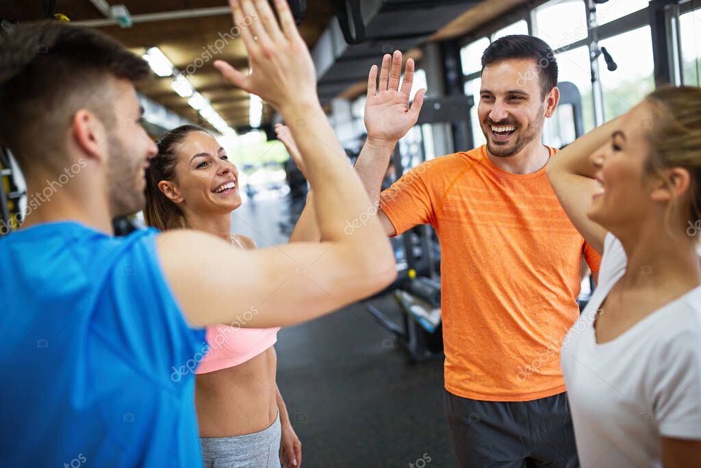 Grupo de personas jóvenes en forma haciendo ejercicios en el gimnasio ...