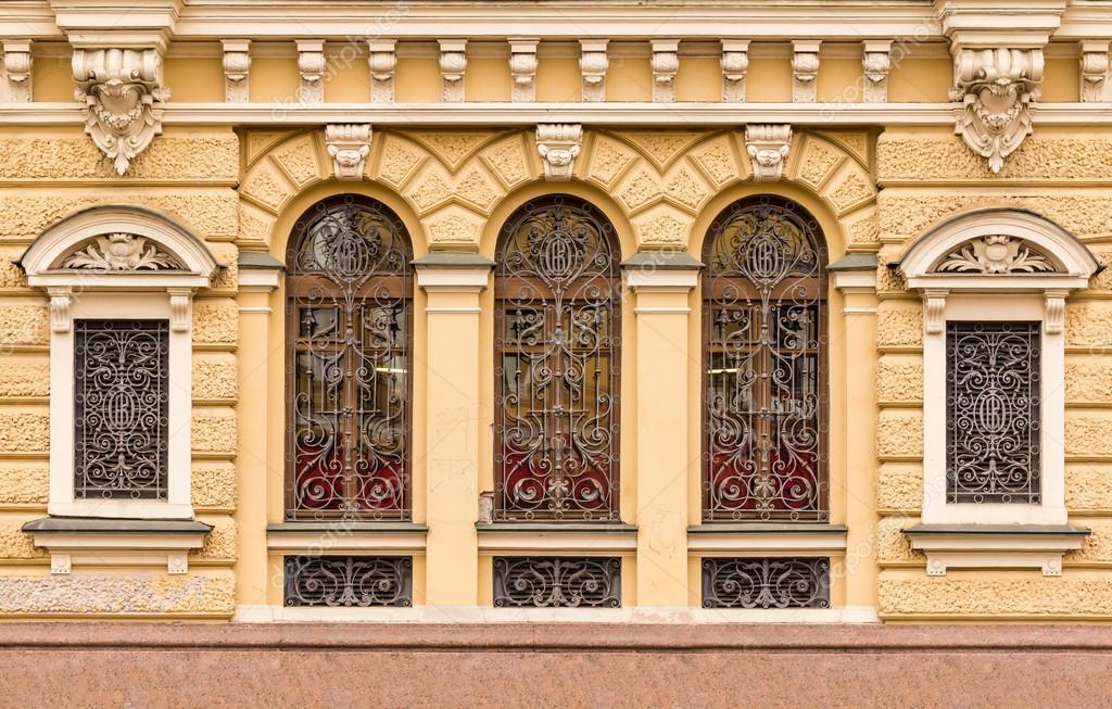 Ventanas en fila con rejilla forjada en la fachada del edificio de ...