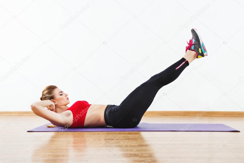 Attractive fit girl doing physical exercises at gym Stock Photo by ...