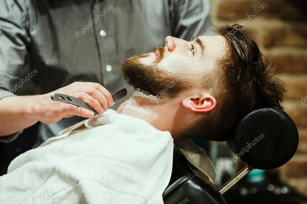 Barber shaving a bearded man Stock Photo by ©VelesStudio 83571962