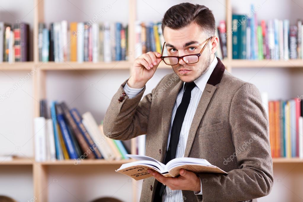 Man posing with a book in the office Stock Photo by ©VelesStudio 85888154