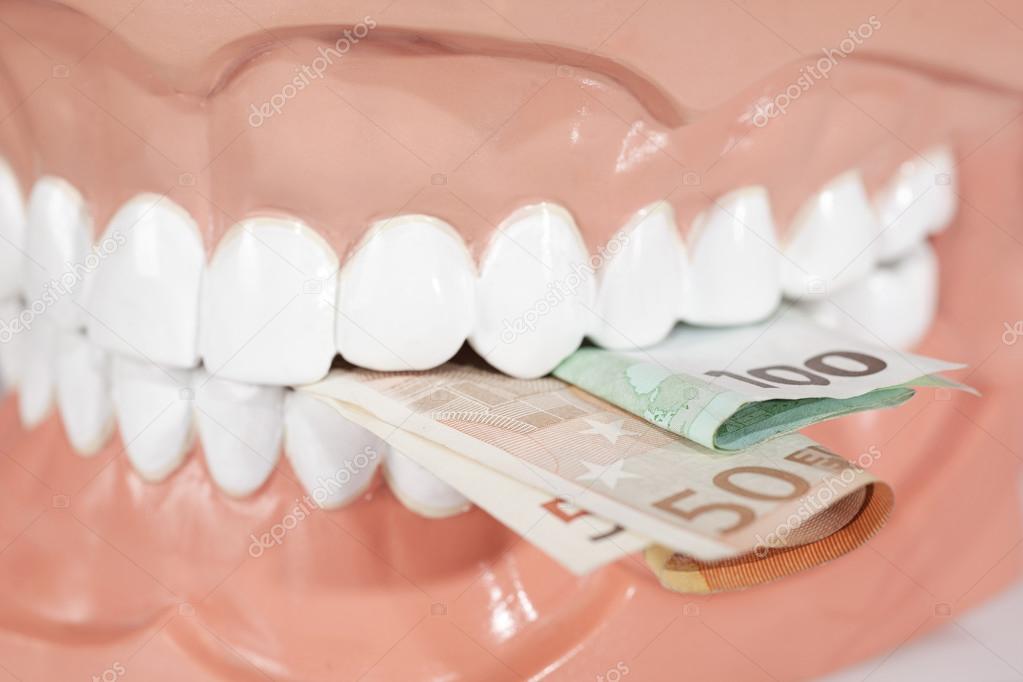 Dentures biting euro banknotes close up Stock Photo by ©TunedIn61 85070904