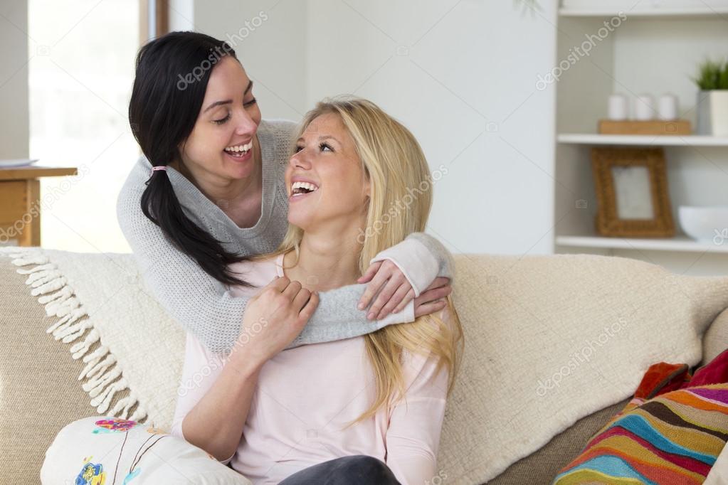Female couple cuddling and smiling at each other Stock Photo by ...