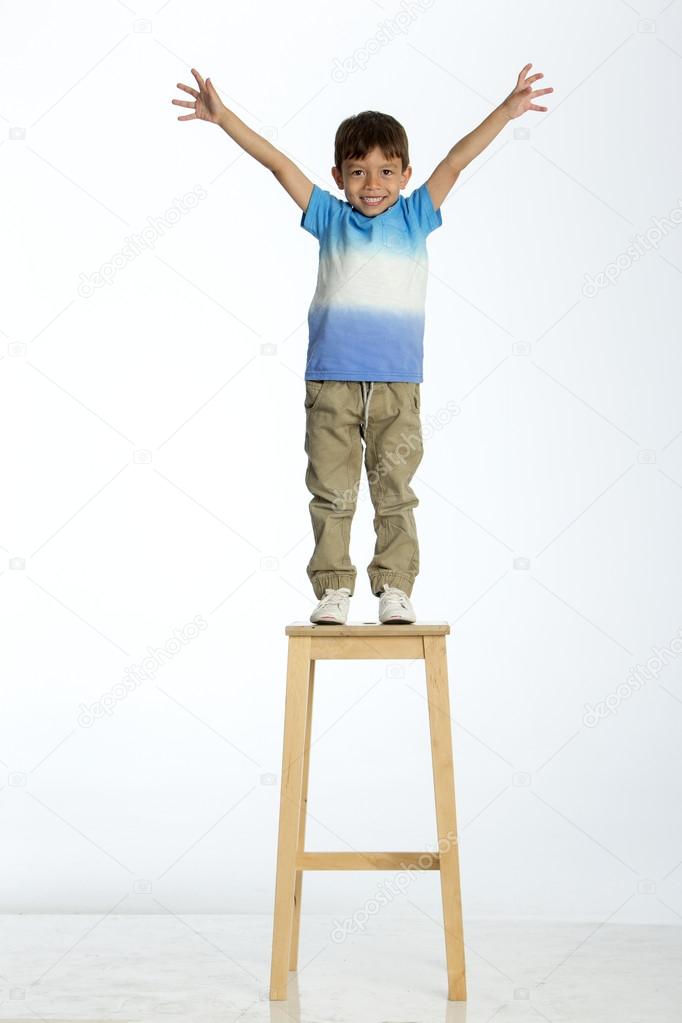 Little boy standing on a high stool Stock Photo by ©DGLimages 81392372