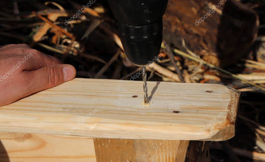 Taladro de carpintero produce una conexión de barras de madera. 2022