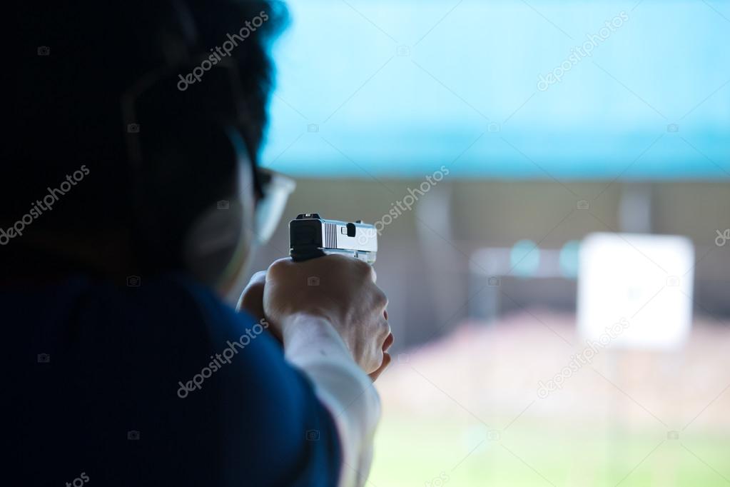 A man aim and shoot pistol by two hand in academy shooting range Stock ...
