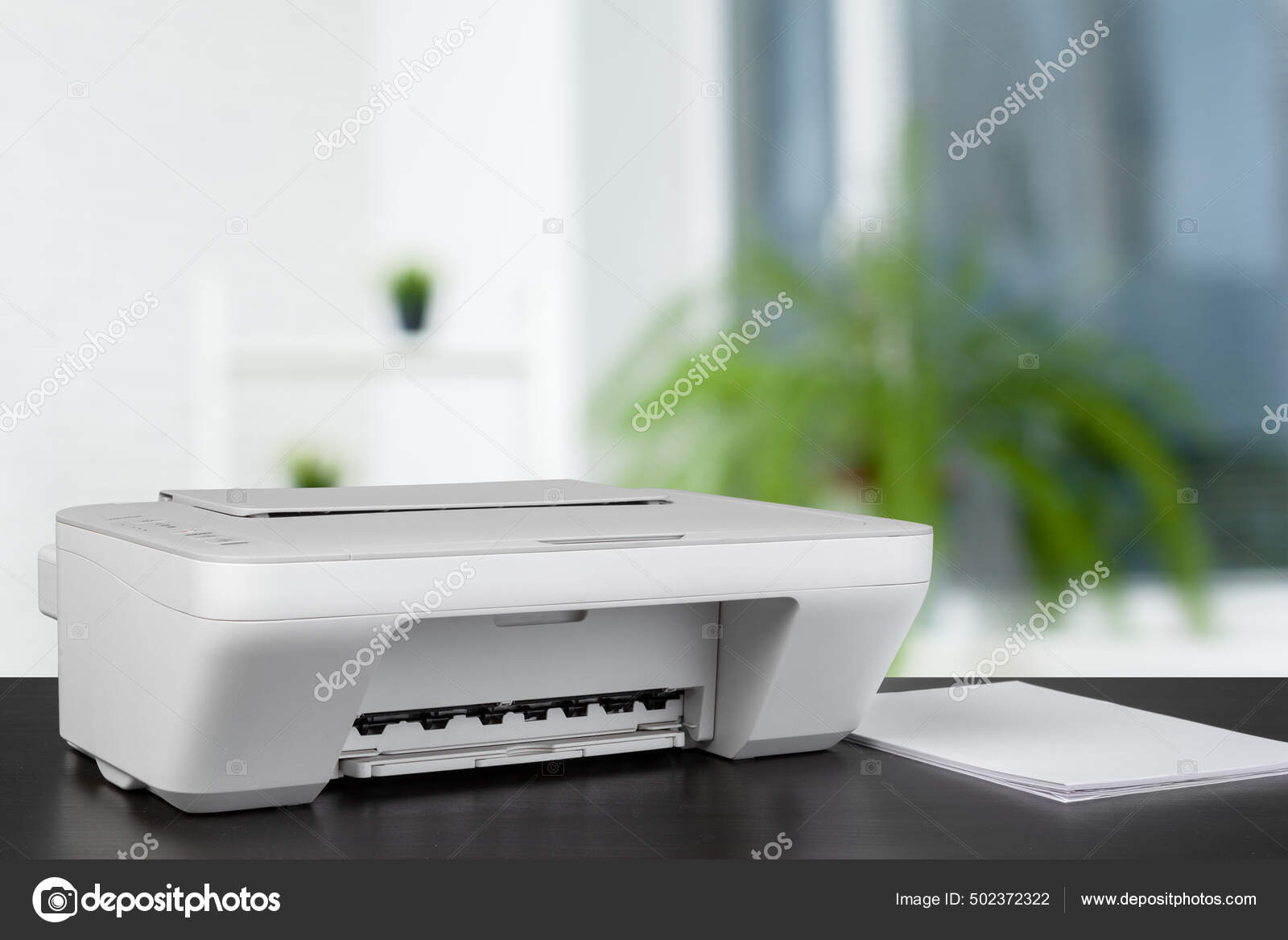 Compact laser printer on black desk against blurred background — Stock ...