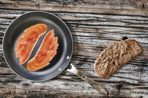 Prosciutto Rashers in Teflon Frying Pan with Bread Slice on very Old ...