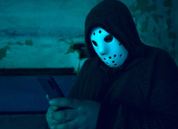 Portrait of computer hacker in white mask and hoodie. Obscured dark ...