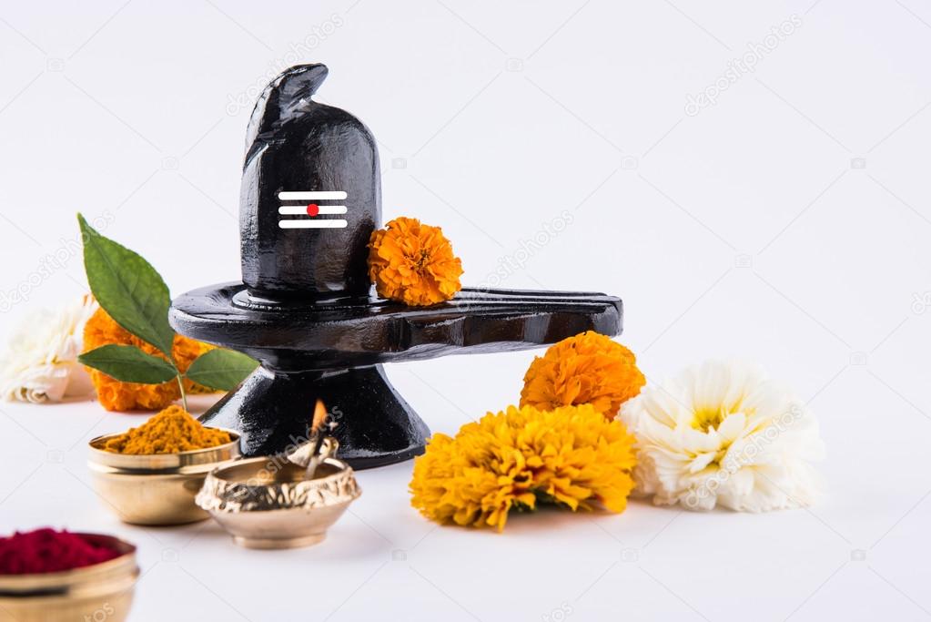 Shiva Linga made up of black stone decorated with flowers & bael leaf ...