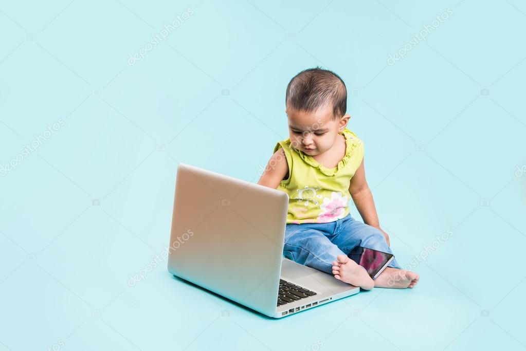 Baby sitting on the floor with a laptop, indian baby girl with laptop ...