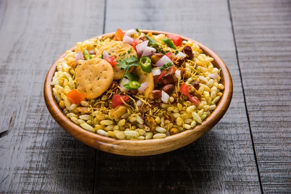 Indian snacks Bhel Puri served with chopped tomatoes, green chillies ...