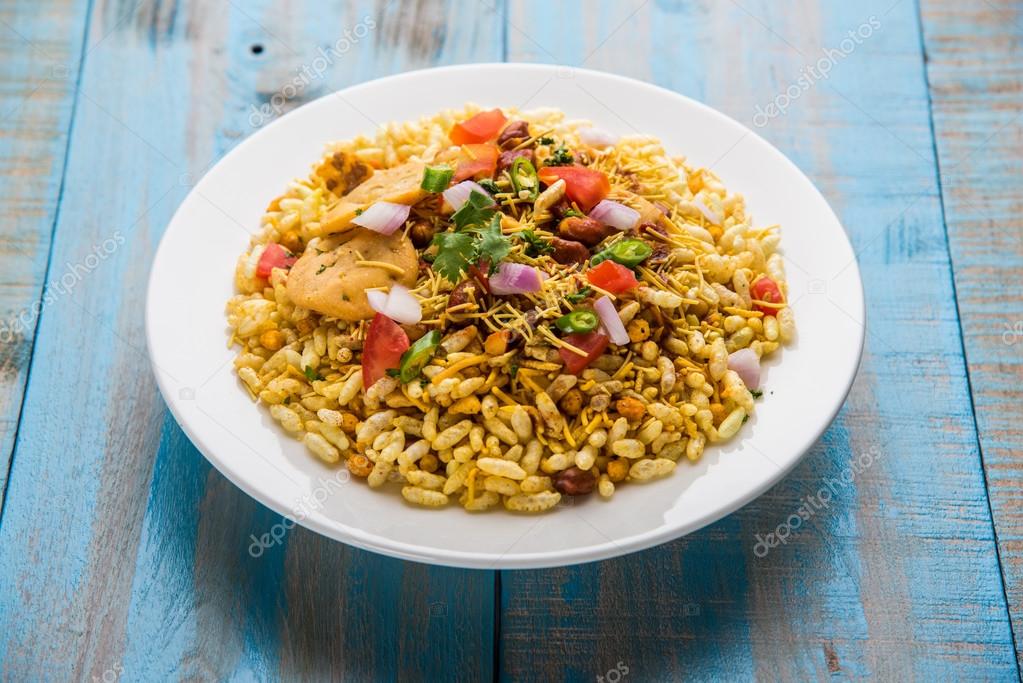 Indian snacks Bhel Puri served with chopped tomatoes, green chillies ...