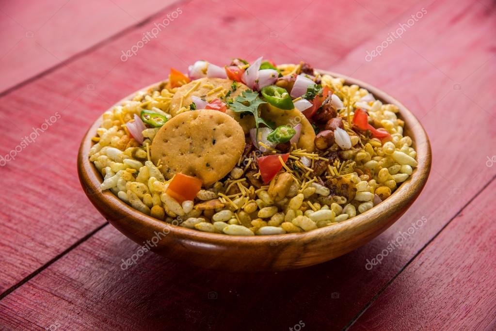 Indian snacks Bhel Puri served with chopped tomatoes, green chillies ...