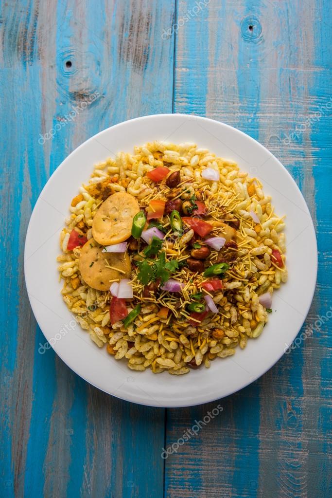 Indian snacks Bhel Puri served with chopped tomatoes, green chillies ...