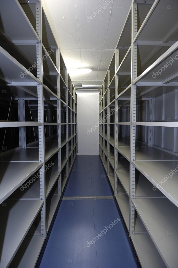 An empty storage unit with shelving on both walls - — Stock Photo ...