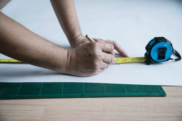 Man using measure hand tool doing wallpaper cutting work in home ...