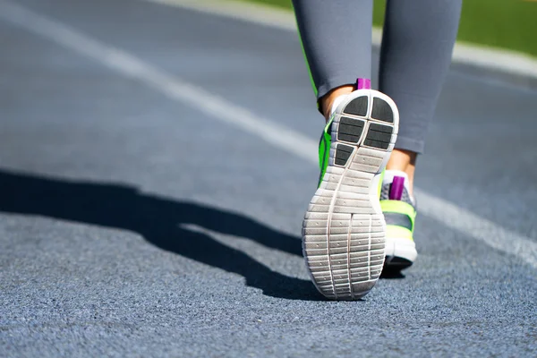 Runner feet running on road closeup on shoe. Woman fitness jog w ...