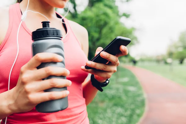 Woman using mobile phone after running - Stock Image - Everypixel