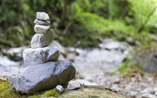 Stack of pebble stones by a stream in a forest - Stock Image - Everypixel