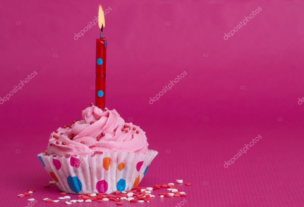 Delicioso cupcake de cumpleaños sobre fondo rosa 2022