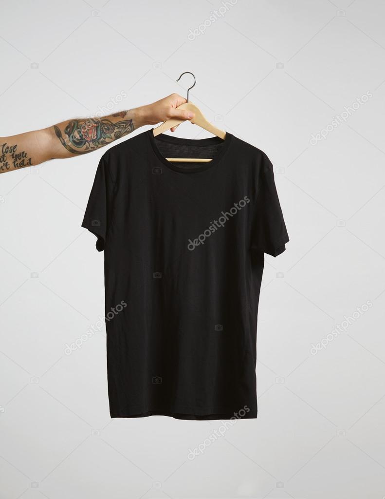Hand holds hang with black t-shirt Stock Photo by ©derepente 116421802