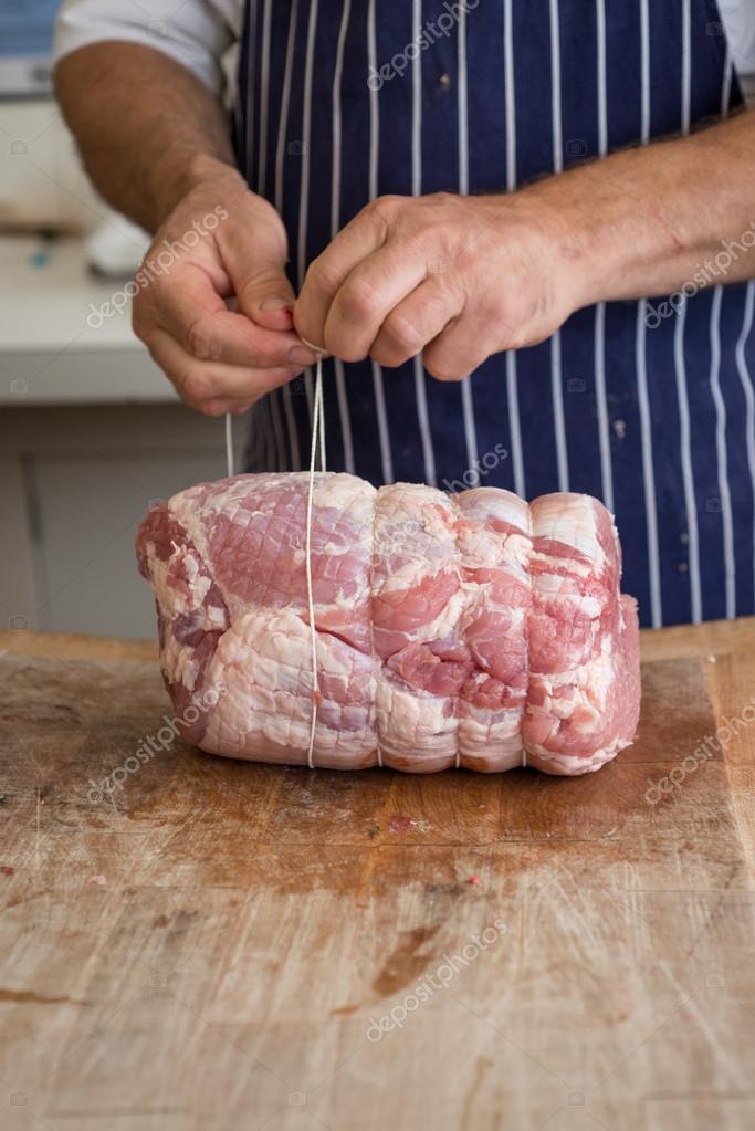 Butcher demonstrating how to tie a joint of ham with string — Stock ...