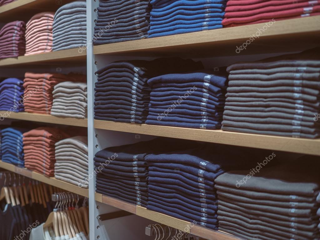 Un armario. Una pila de ropa cuidadosamente doblada. Bastidor de suave ...