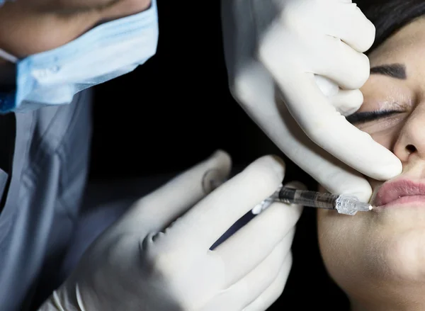 Doctor cosmetologist doing botox injection syringe. The doctor does an ...