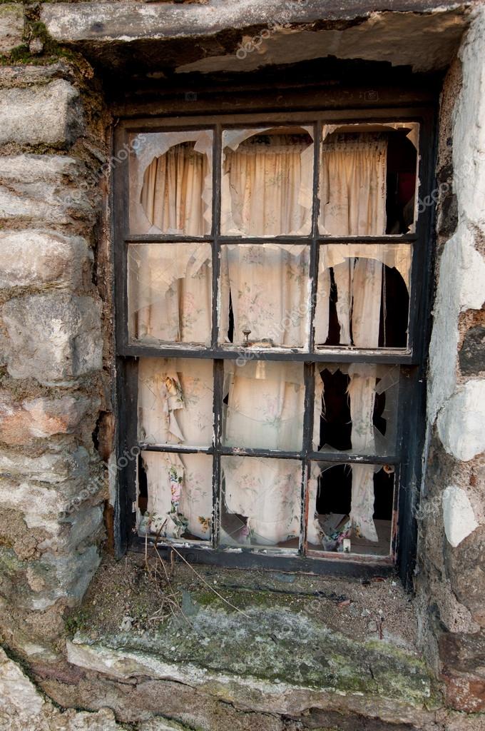 Broken window of a derelect cottage Stock Photo by ©Cornfield 111516200