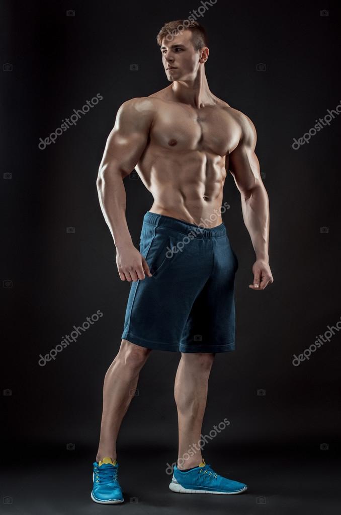 Muscular Culturista Chico Haciendo Posando Sobre Fondo Negro Fotografía De Stock © Nazarov