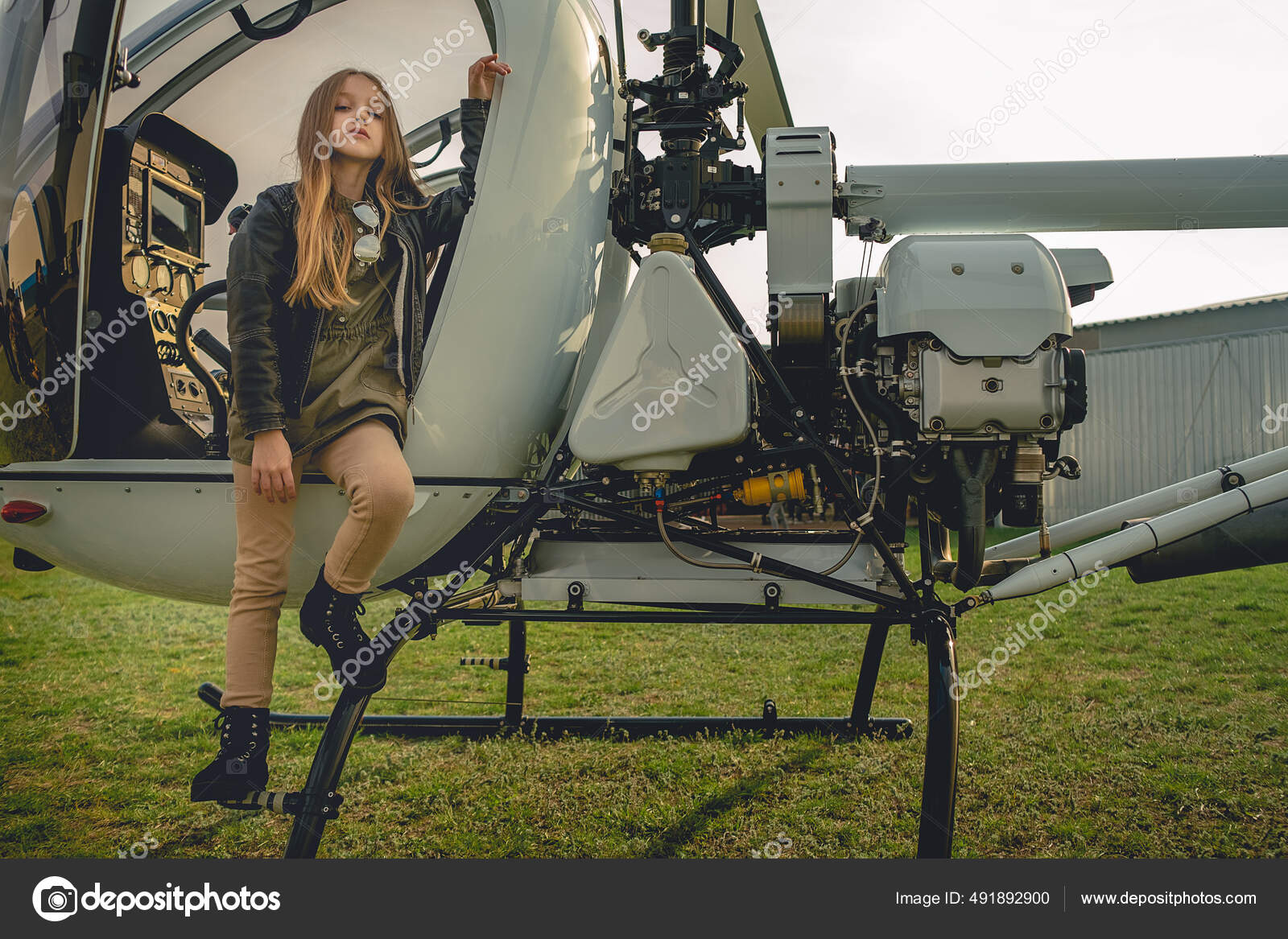 Tween girl posing near open cockpit of helicopter Stock Photo by ...