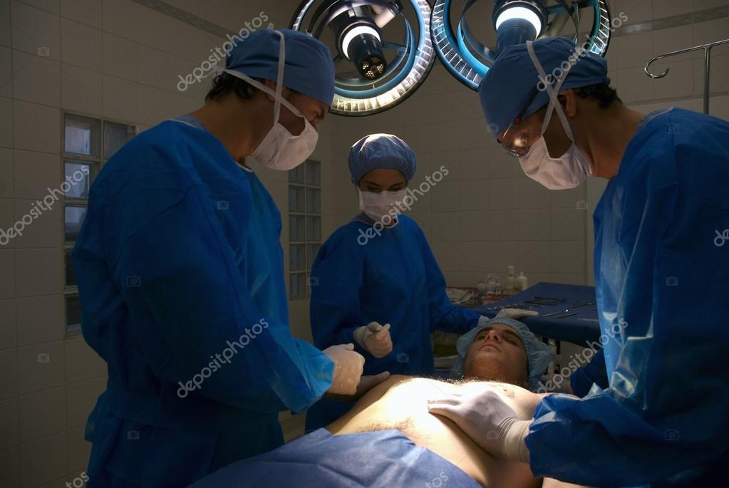 Professional doctors operating man — Stock Photo © Focusarg #93773752