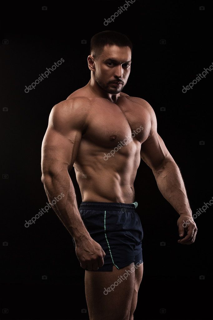 Handsome muscular bodybuilder posing on a black background Stock Photo ...