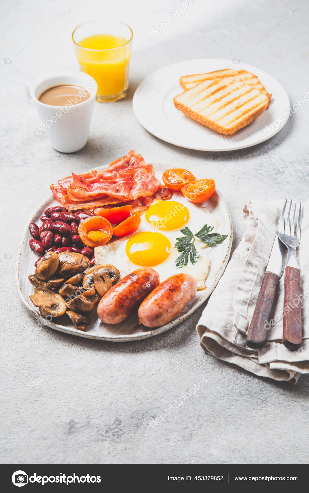 English Breakfast with fried eggs, sausages, bacon, beans, toasts ...