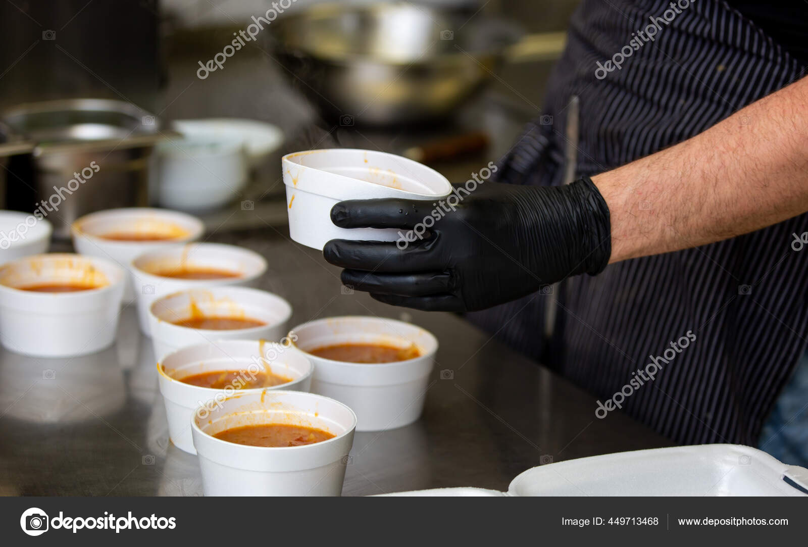 Chef preparing soup to a box in the restaurant for food delivery ...