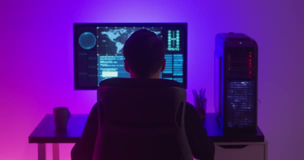 Rear view of man programmer coding network security software indoors in ...